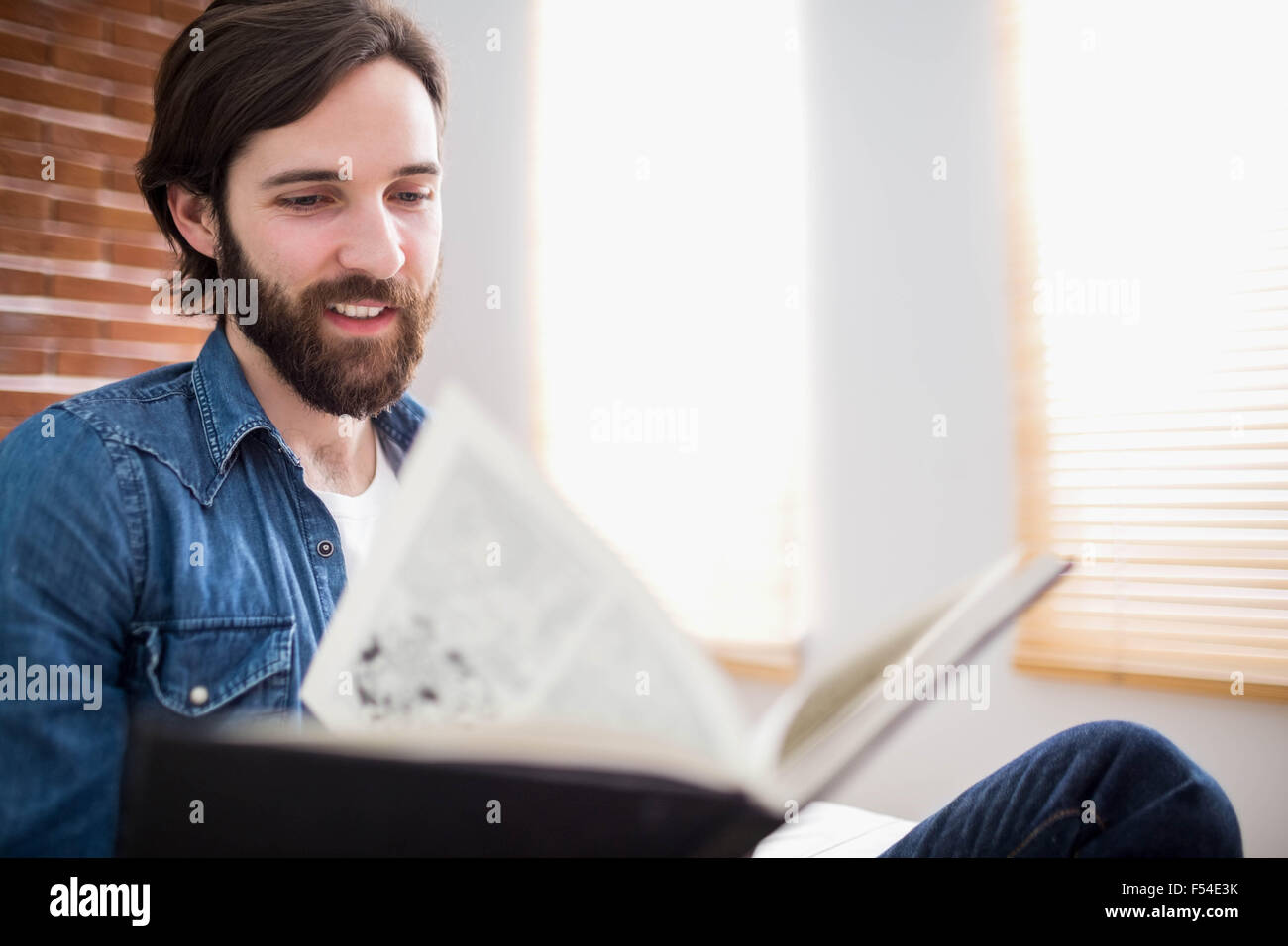 Casual man reading on his sofa Stock Photo - Alamy