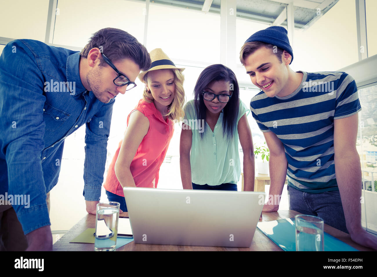 Creative business team working hard together on laptop Stock Photo - Alamy