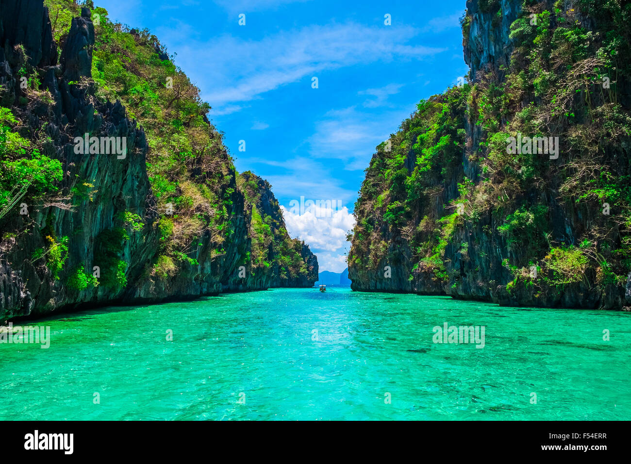 Tropical landscape with rock islands, lonely boat and crystal clear ...