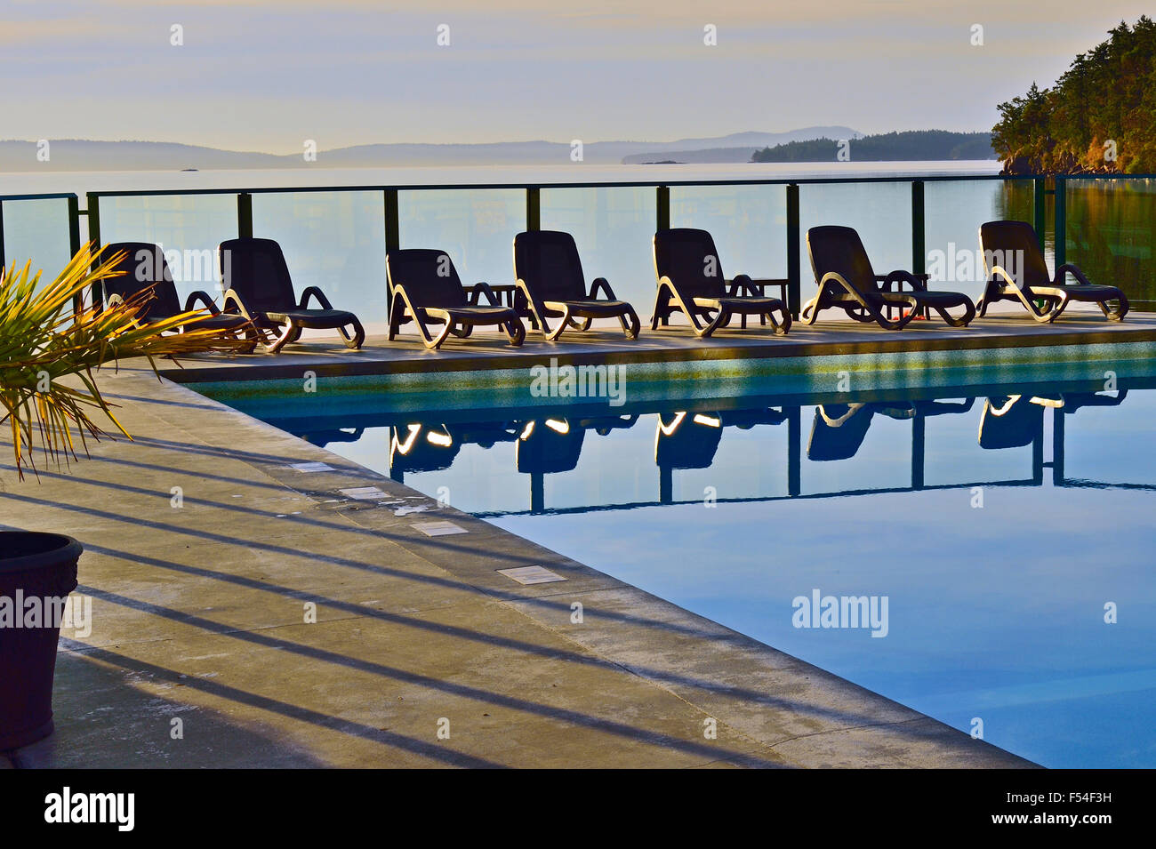 A horizontal image of a line of chairs at an outdoor swimming pool at ...
