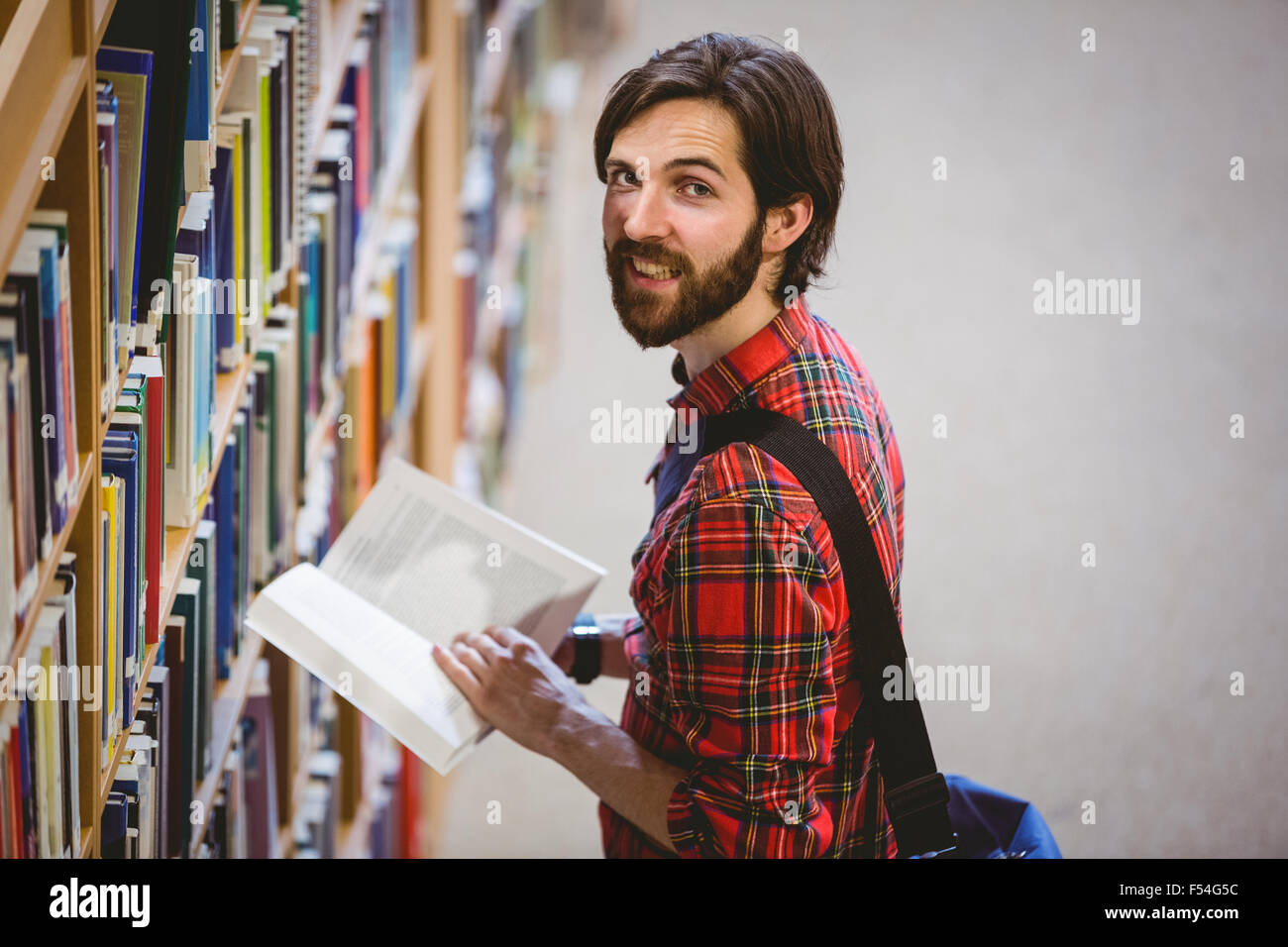 Student picking a book from shelf in library Stock Photo - Alamy