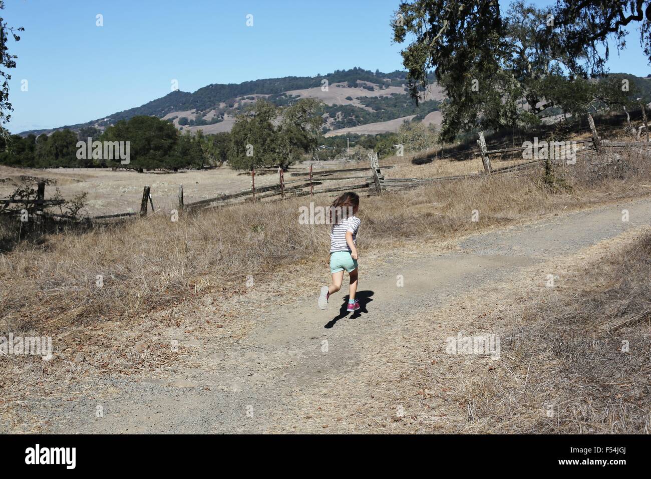 A small girl running alone on a trail in California Stock Photo - Alamy