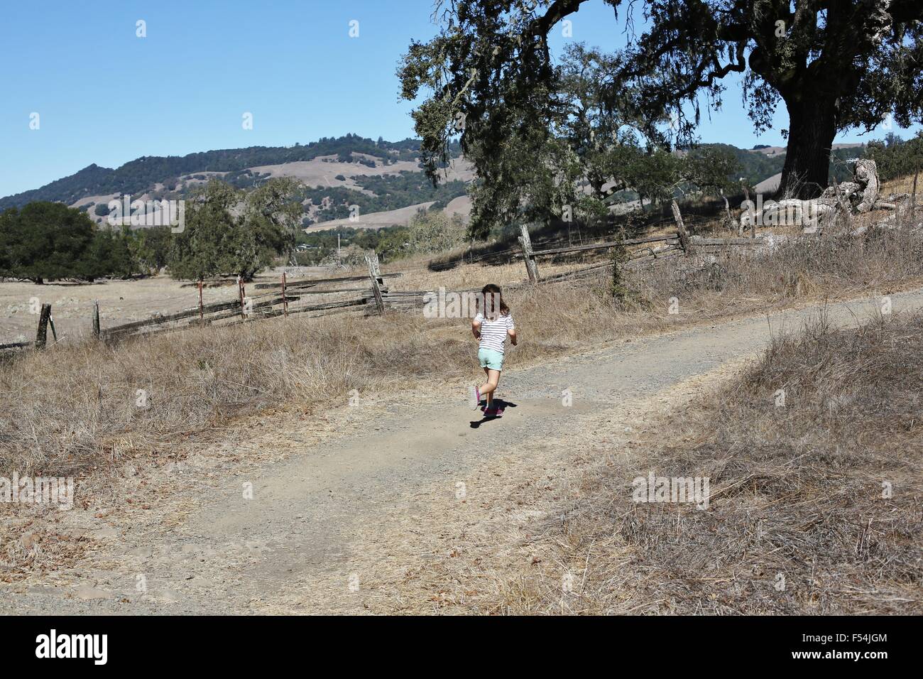 A small girl running alone on a trail in California Stock Photo - Alamy