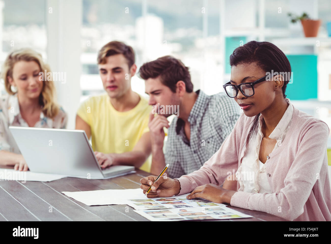 Creative business team working hard together on laptop Stock Photo - Alamy