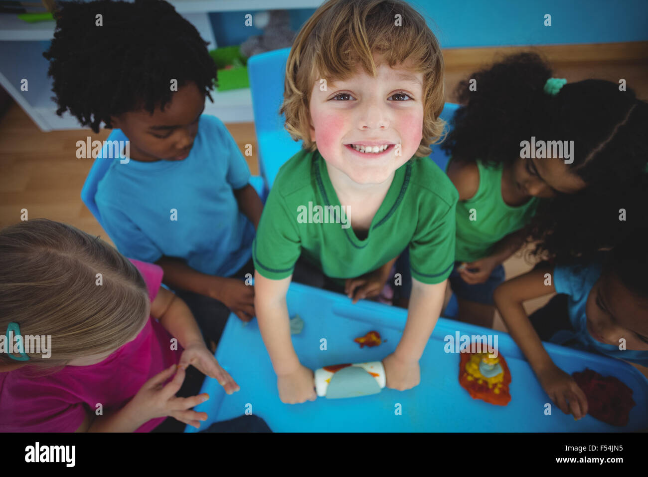 Smiling kids playing with modelling clay Stock Photo - Alamy