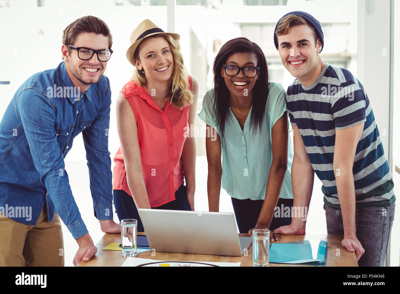 Creative business team working hard together on laptop Stock Photo - Alamy
