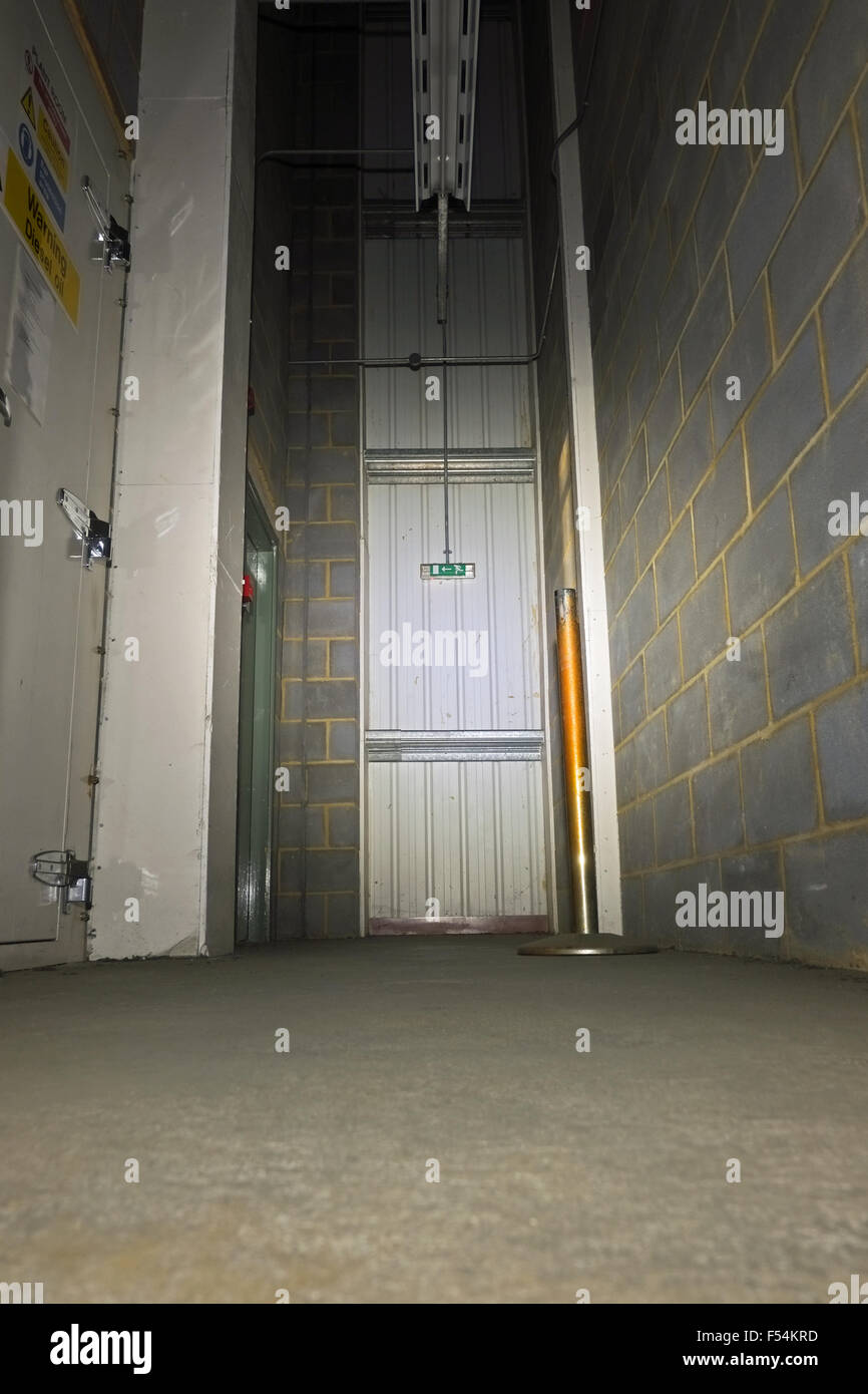 Poorly lit corridor and exit door UK Stock Photo - Alamy