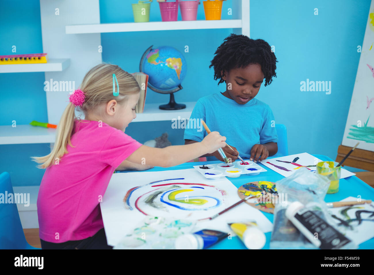 Happy kids enjoying arts and crafts painting Stock Photo - Alamy