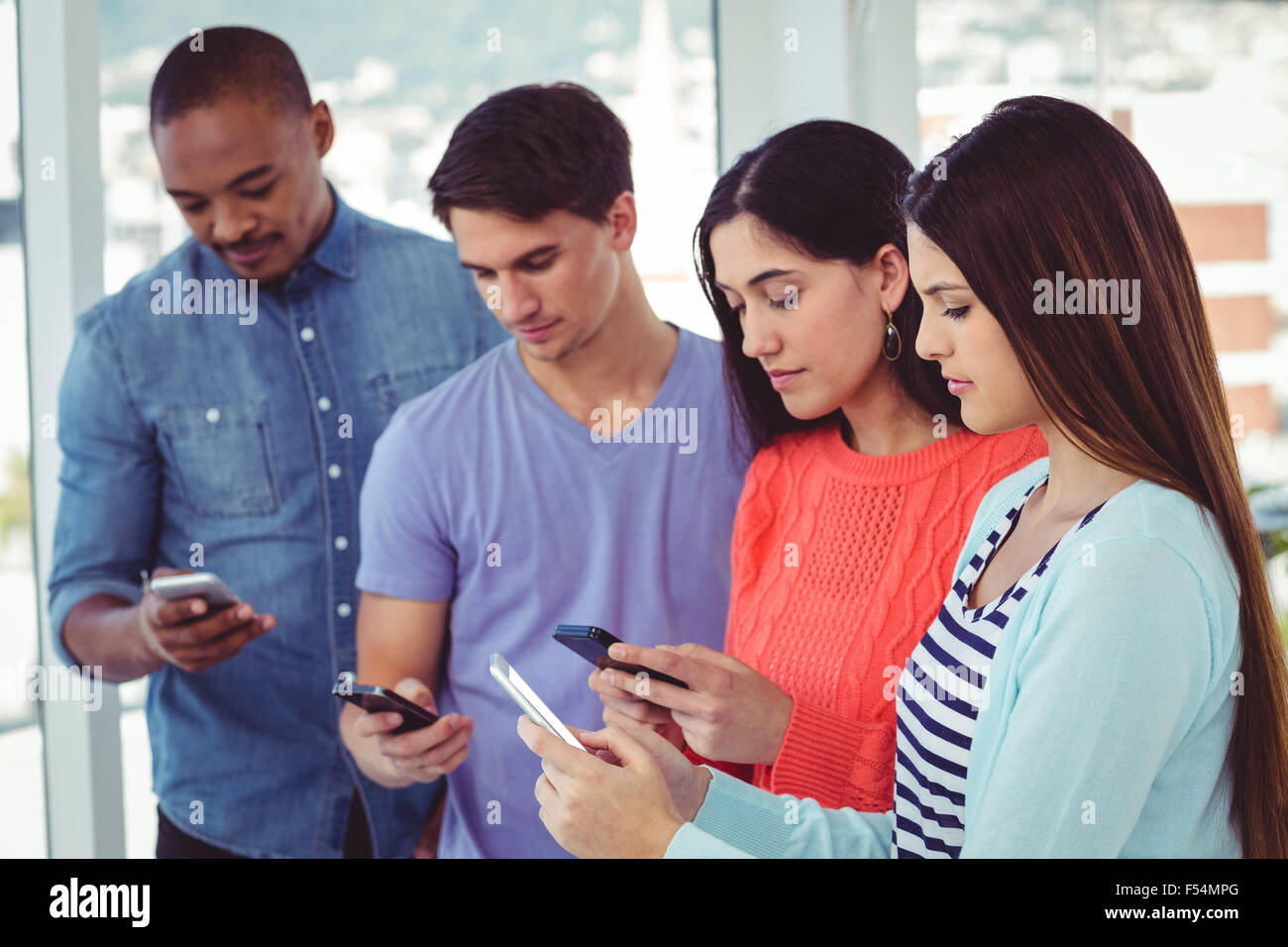 Group looking at phones hi-res stock photography and images - Alamy