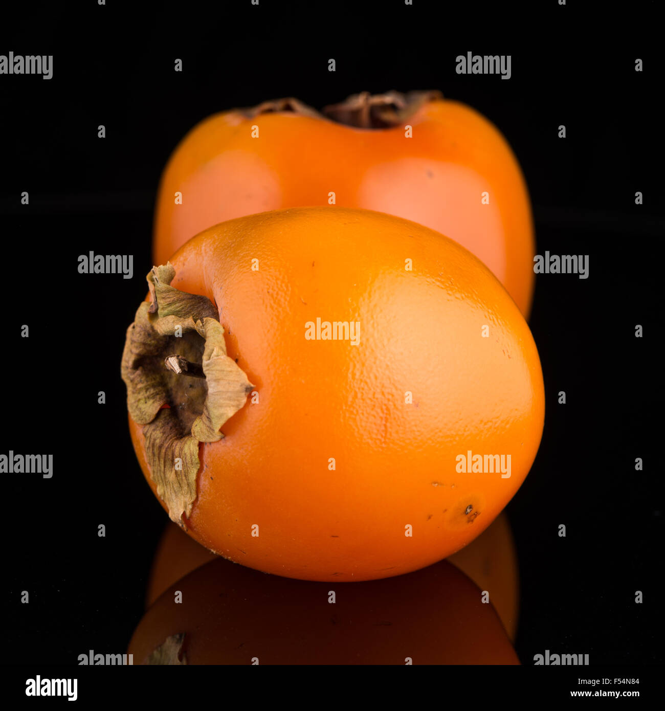 Persimmon fruits on black background Stock Photo - Alamy