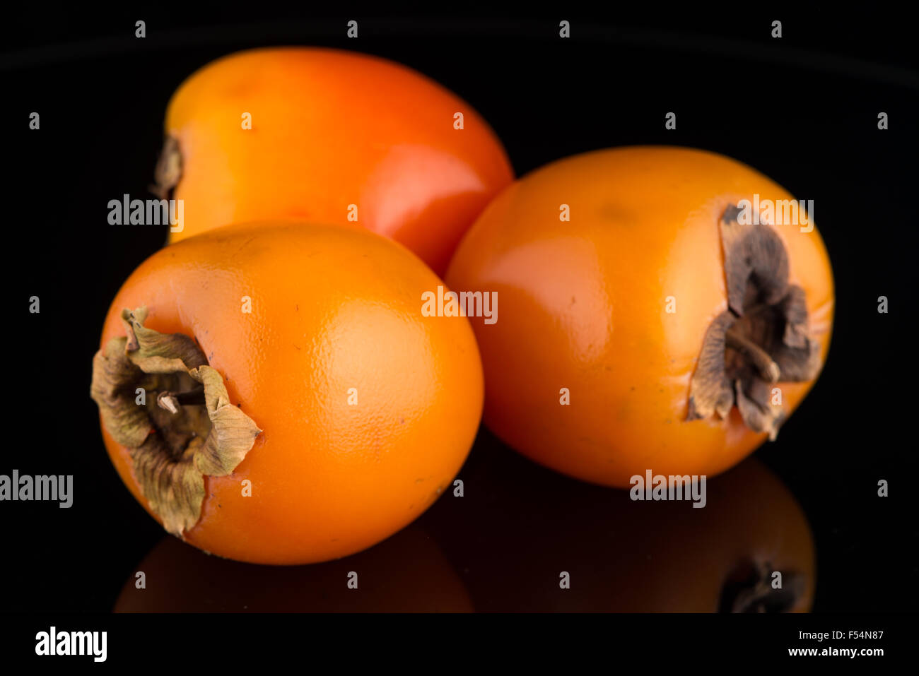 Persimmon fruits on black background Stock Photo - Alamy