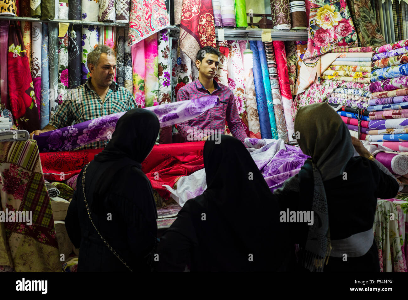 Woman choosing textile at the stall in Grand bazaar in Tehran, Iran ...