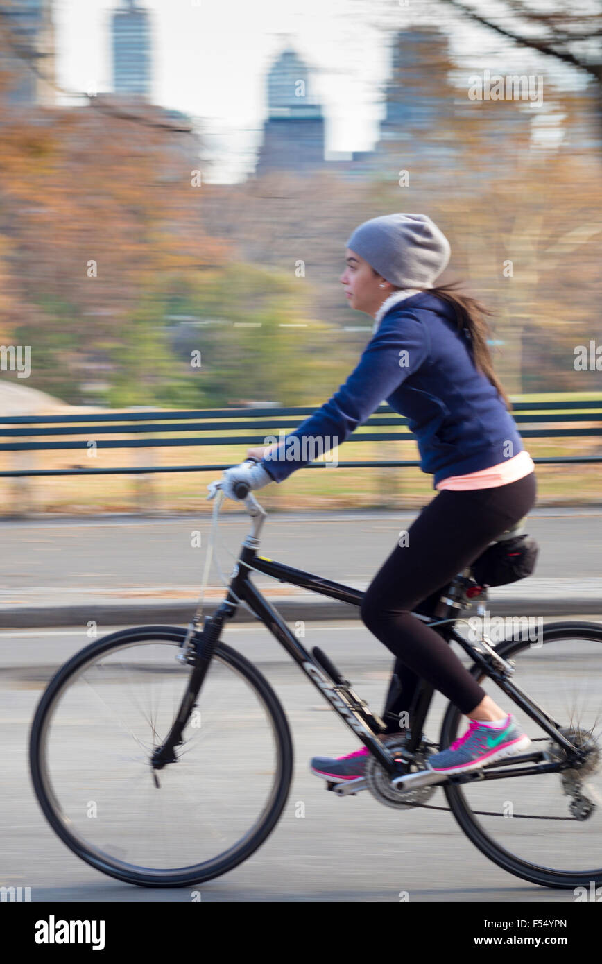 Female cyclist bike riding in winter time in Central Park, New York ...