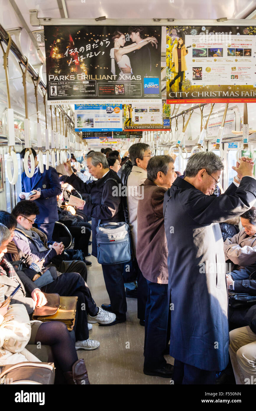 Japan, Osaka. Interior of crowded busy Nankai railway commuter train ...