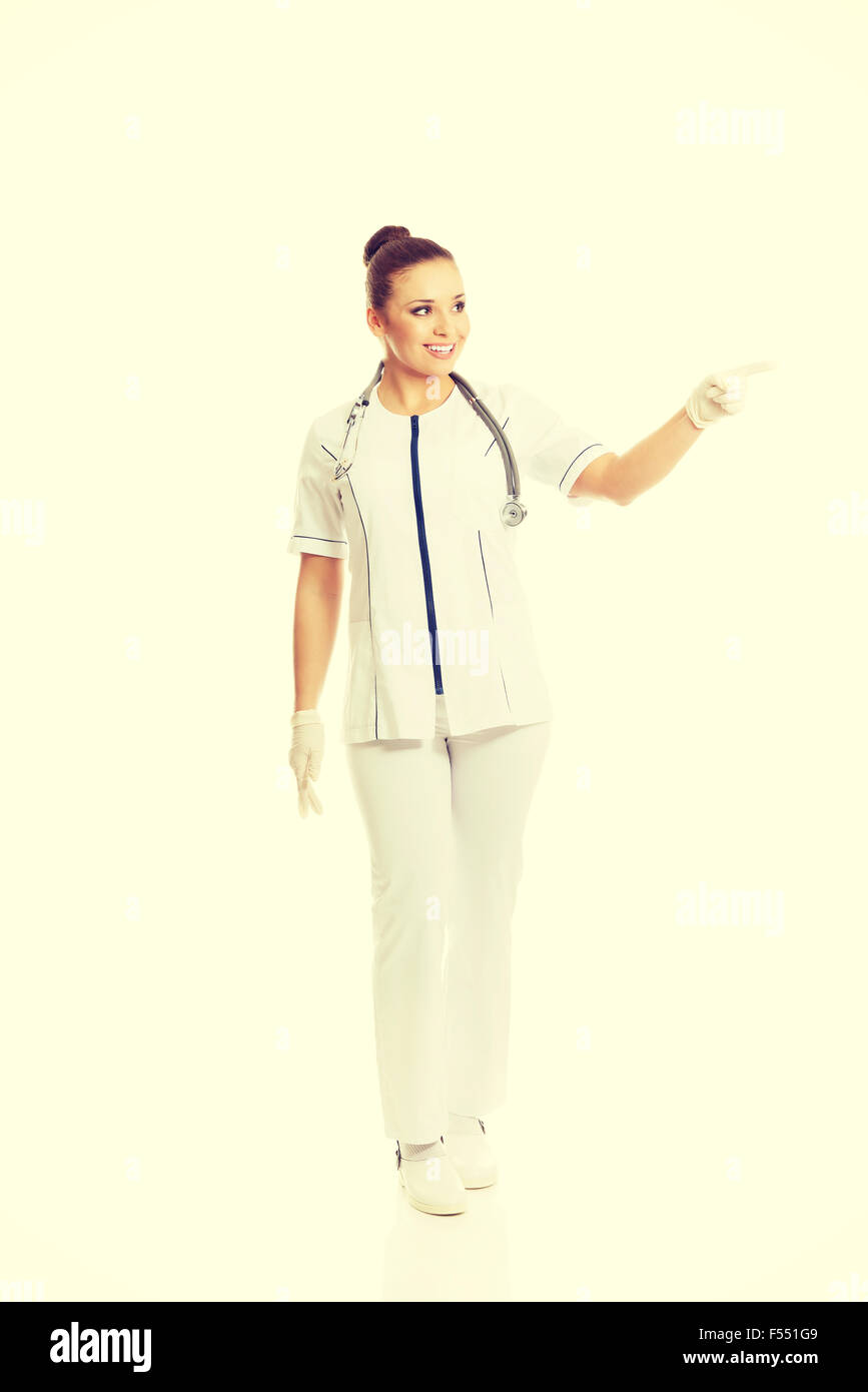 Female doctor pointing to the right Stock Photo - Alamy