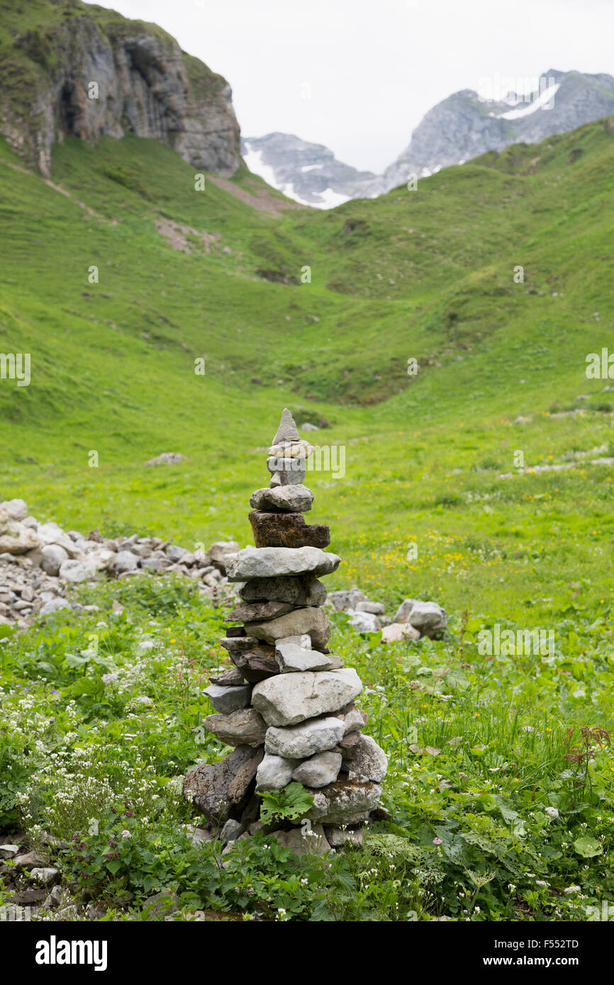 Stones stacked on grassy mountain Stock Photo - Alamy