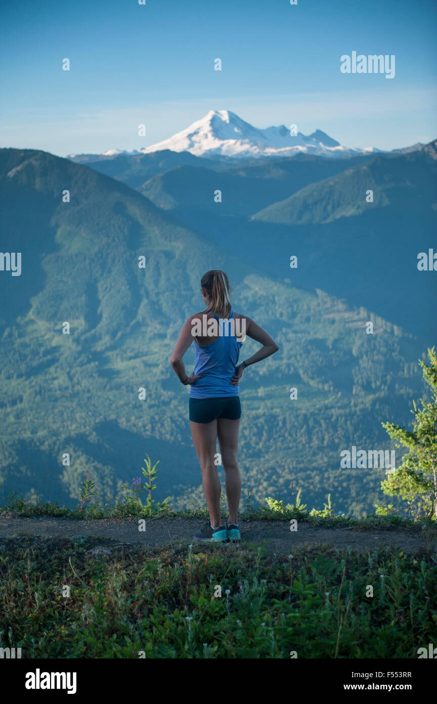 Full length rear view of sporty woman looking at mountain view Stock ...