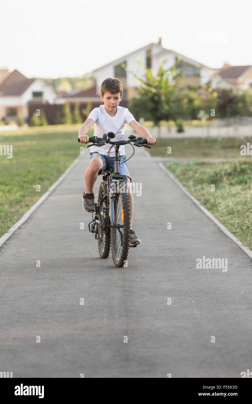 Boy cycling on footpath Stock Photo - Alamy