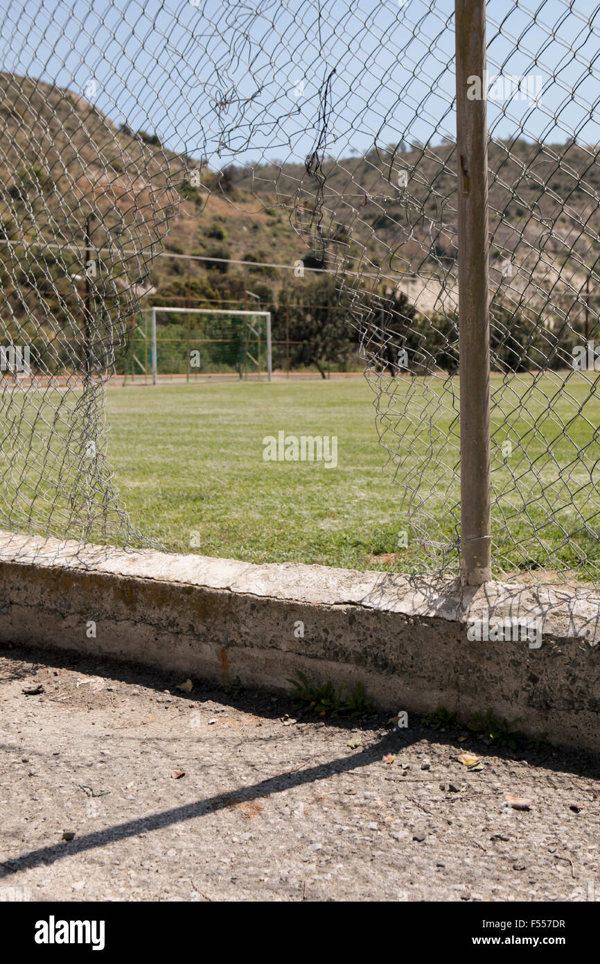 Damaged chainlink fence against soccer field Stock Photo - Alamy