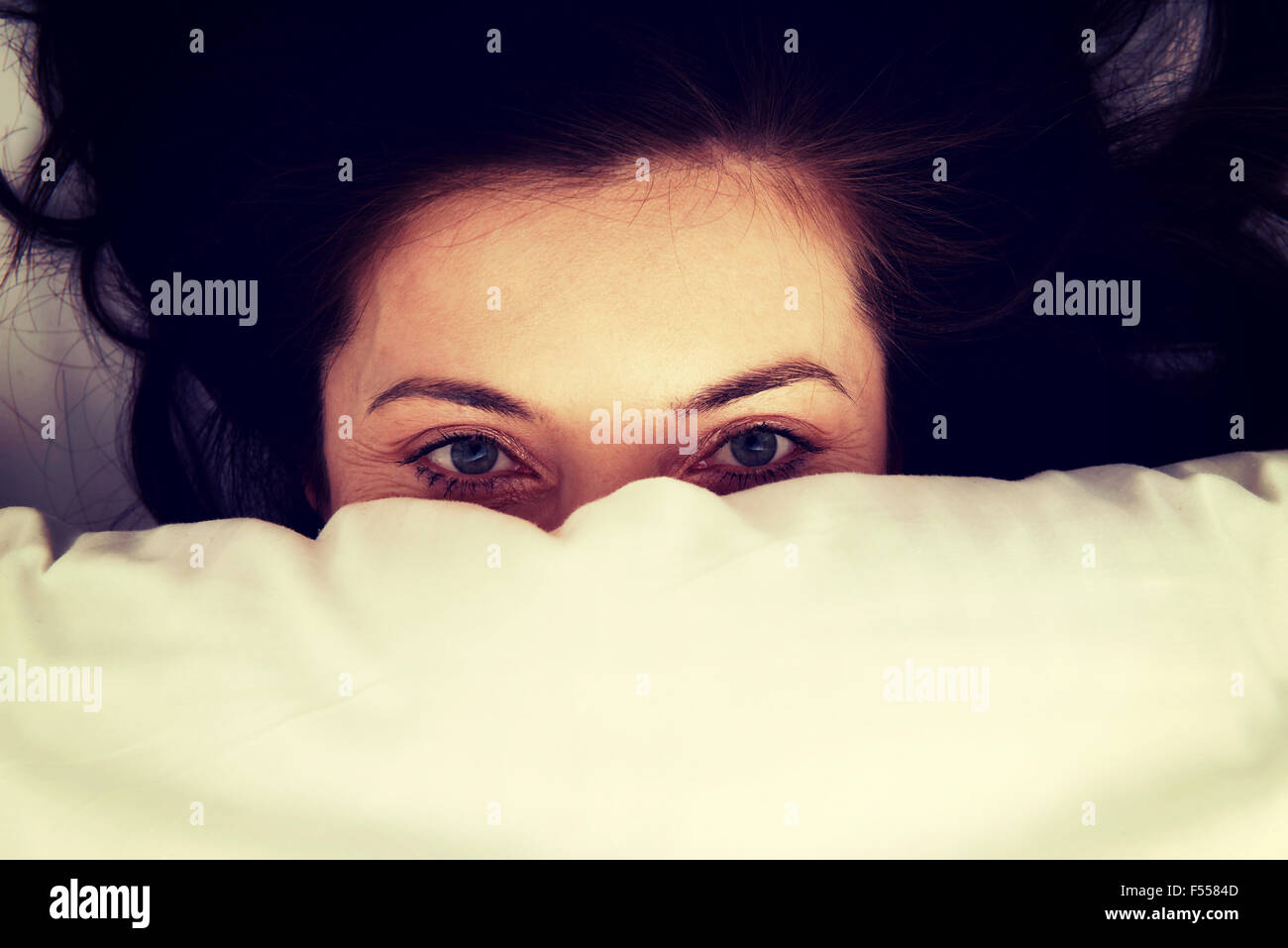 Scared woman in bed Stock Photo - Alamy