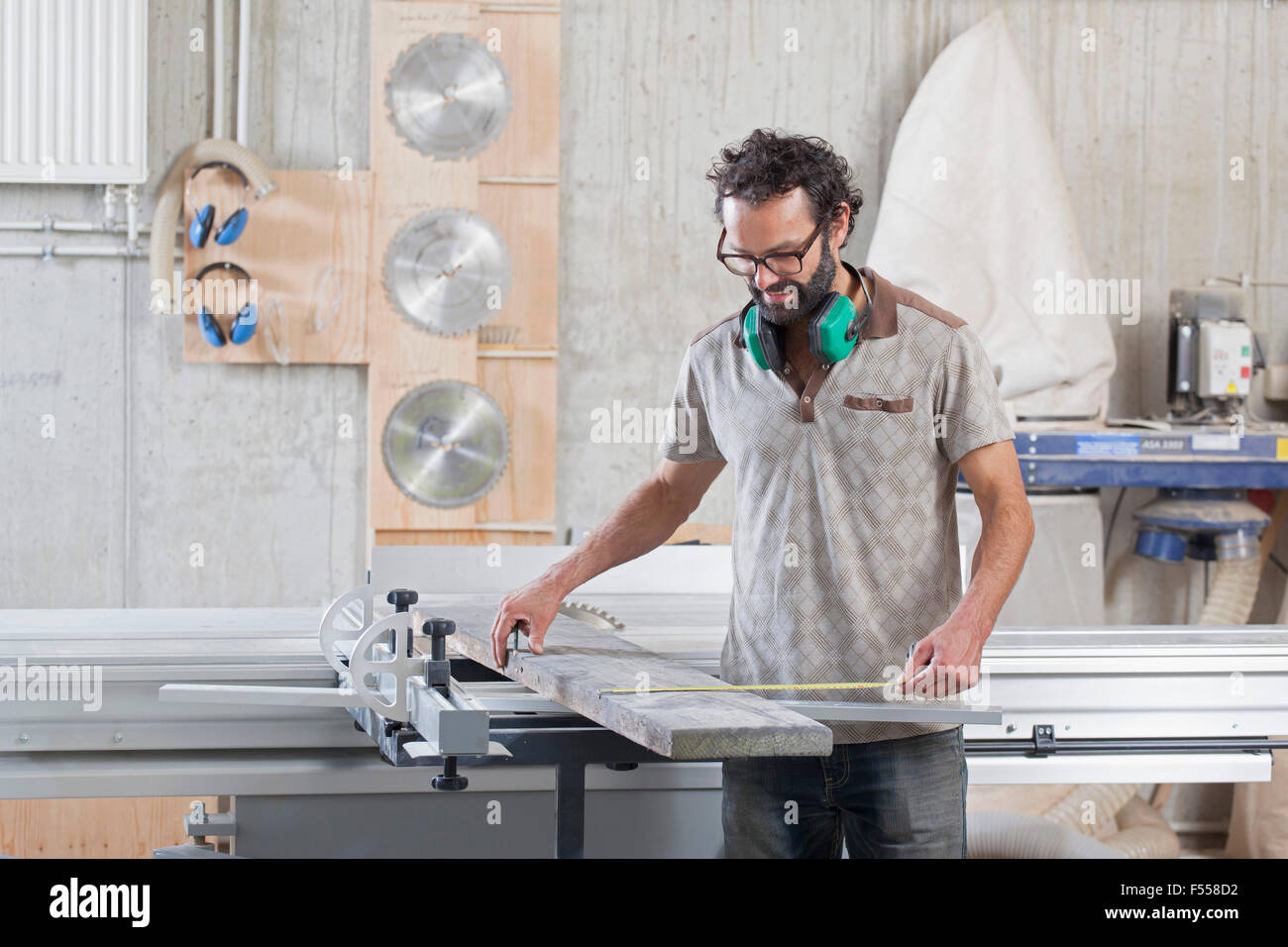 Male carpenter measuring lumber in workshop Stock Photo - Alamy