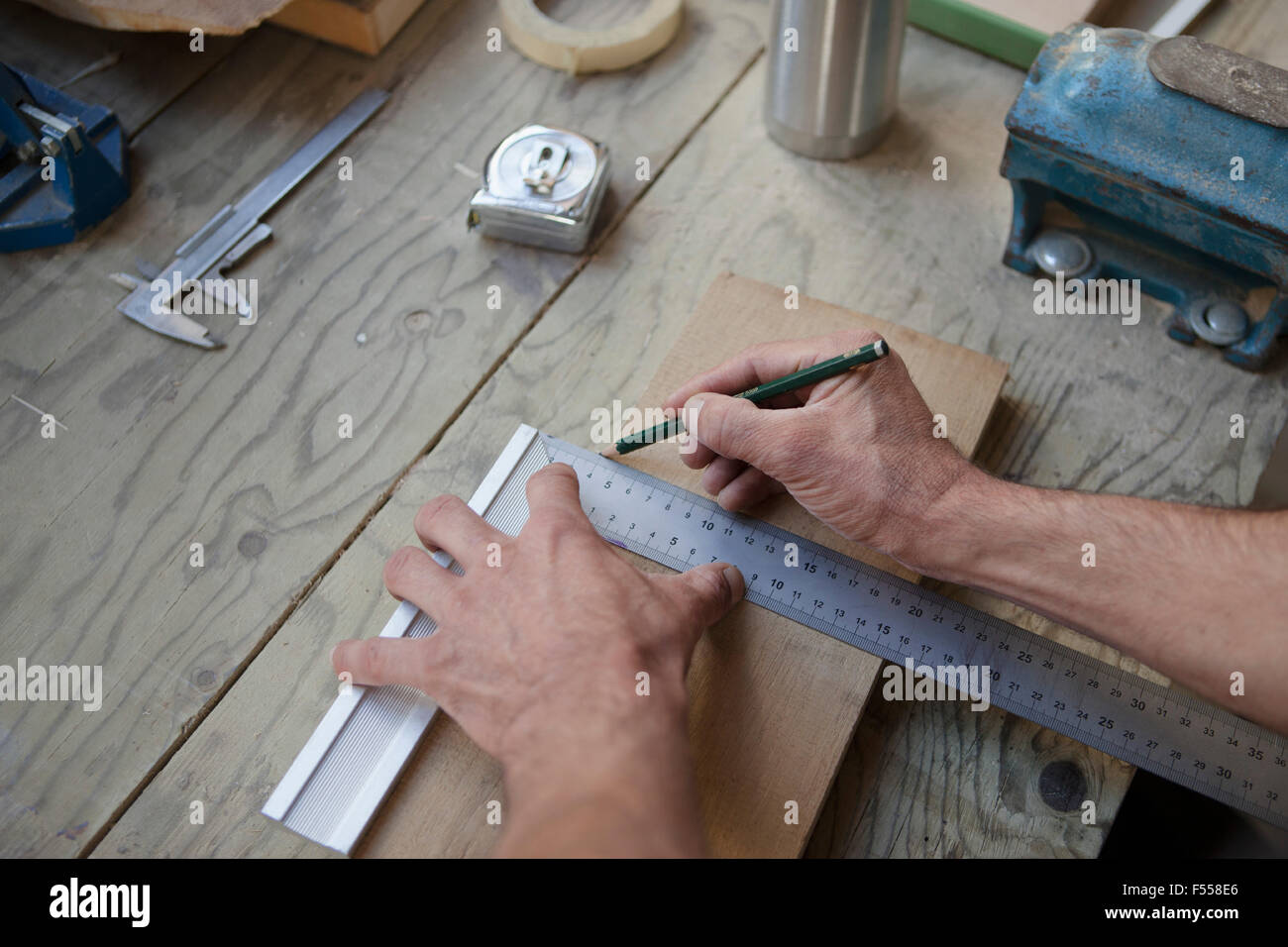 Cropped image of male carpenter marking on plank in workshop Stock ...