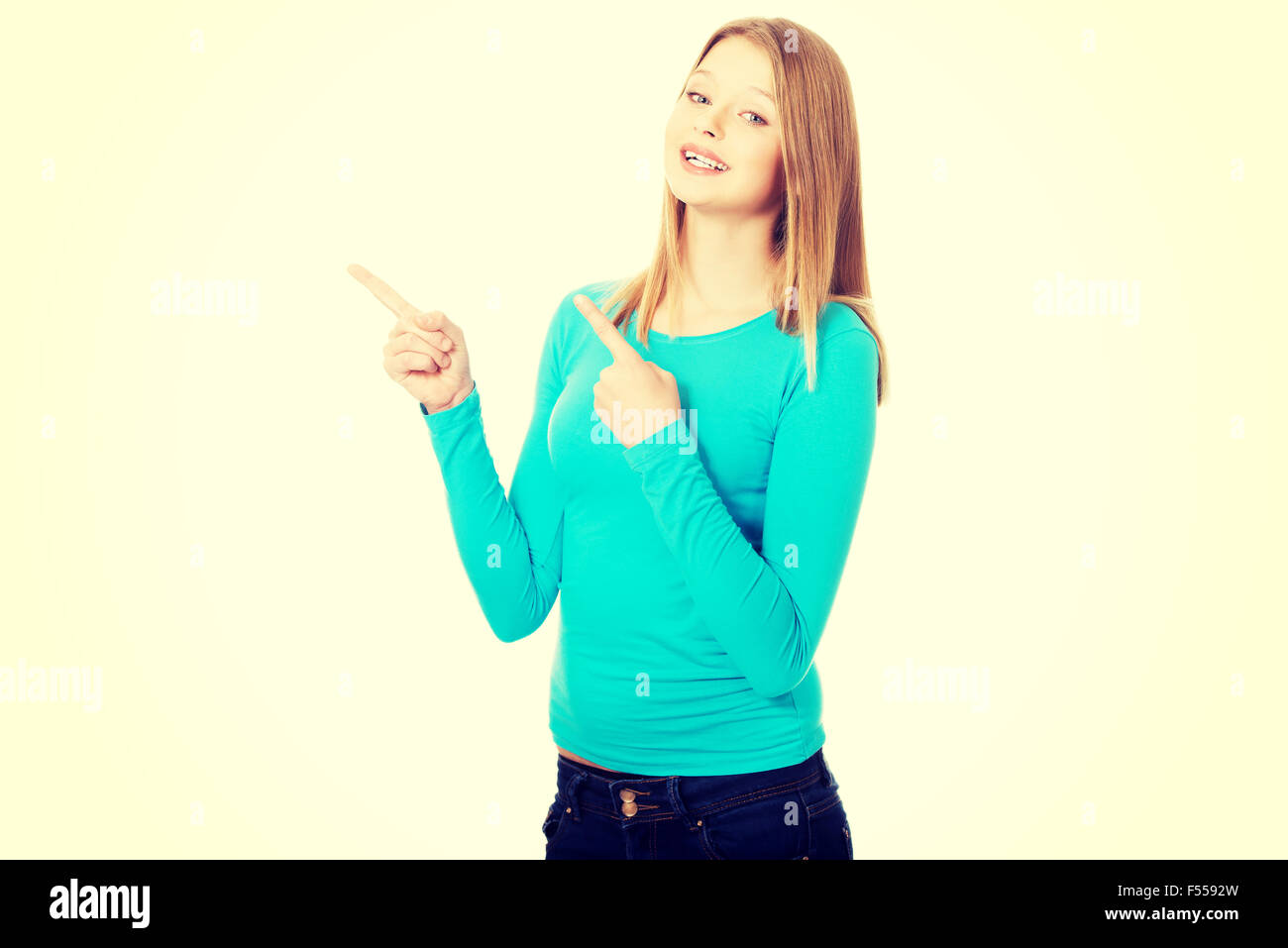 Young woman pointing with both hands Stock Photo - Alamy