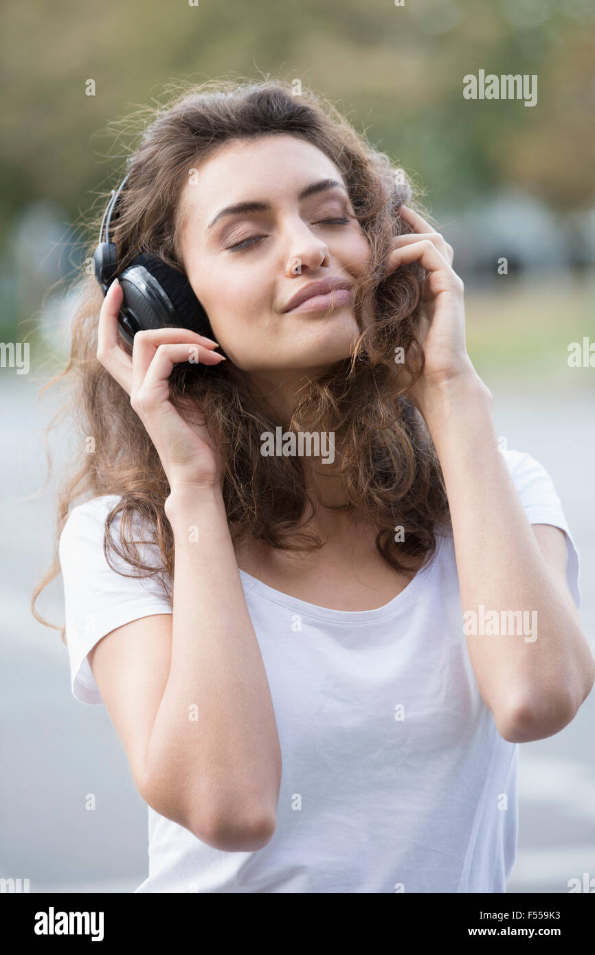 Young woman enjoying listening music outdoors Stock Photo - Alamy