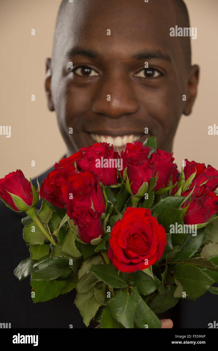 Portrait of happy man with roses against colored background Stock Photo ...
