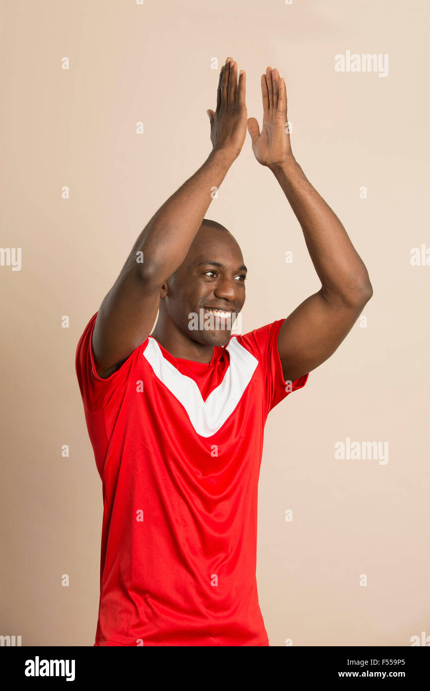 Happy soccer player applauding against colored background Stock Photo ...