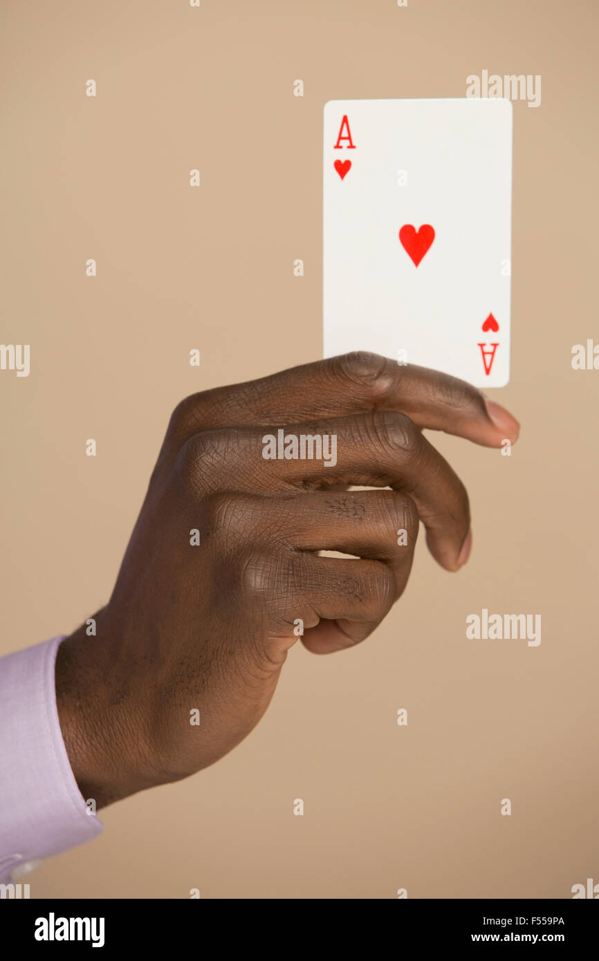 Cropped hand holding ace card against colored background Stock Photo ...