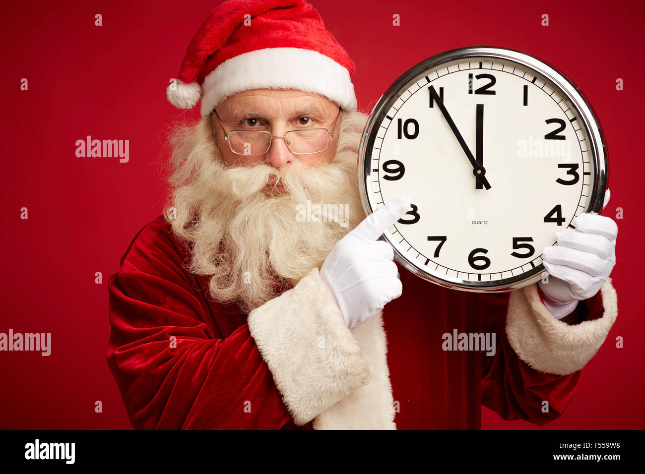 Santa showing at clock before Christmas night Stock Photo - Alamy