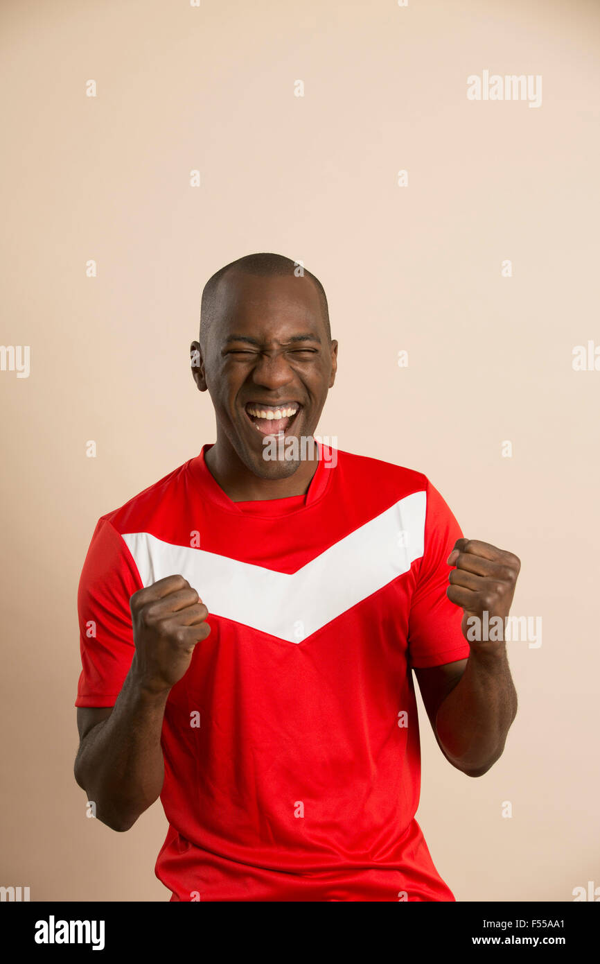 Excited soccer player screaming against colored background Stock Photo ...