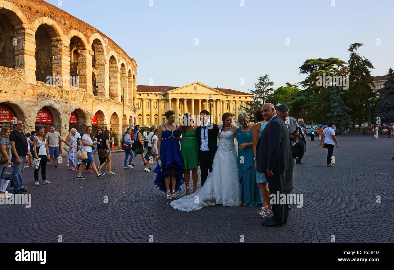 Wedding party posing for photogrpher in front of Roman amphitheatre at ...