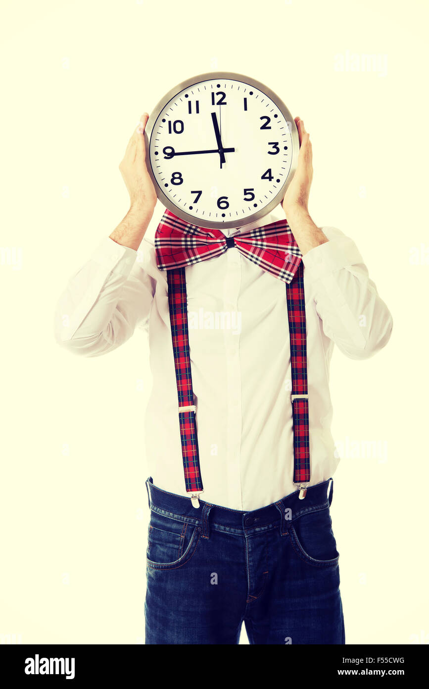 Man wearing suspenders hiding behind big clock Stock Photo - Alamy