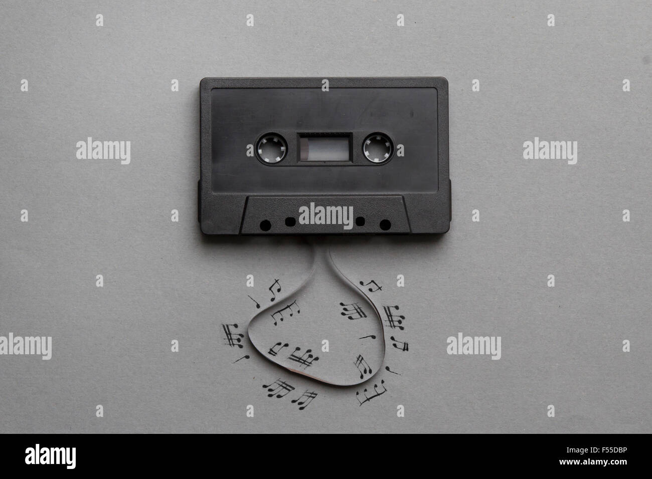 High angle view of music notes drawn around cassette reel on gray ...