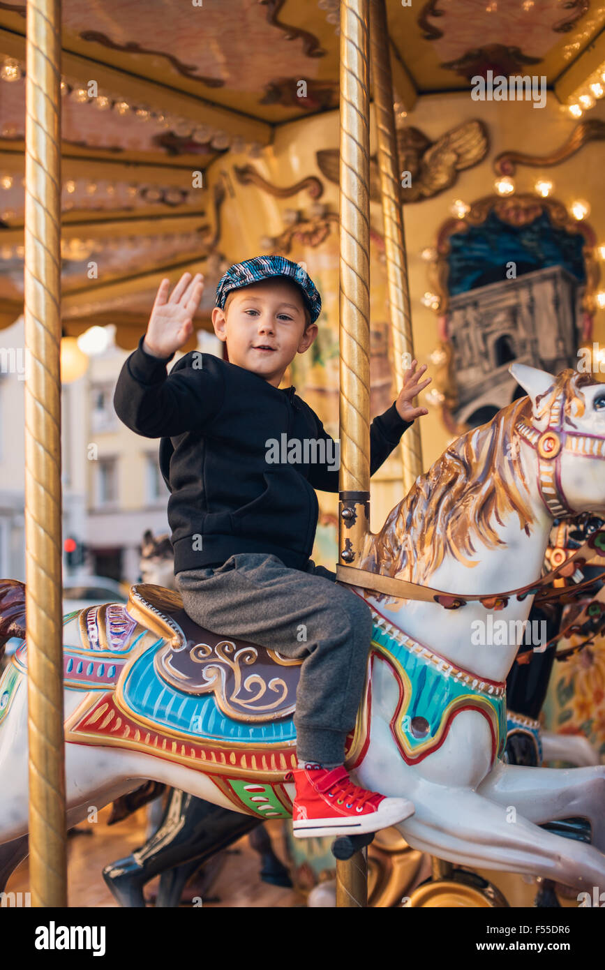 Little boy enjoying his ride at carousel in amusement park Stock Photo ...