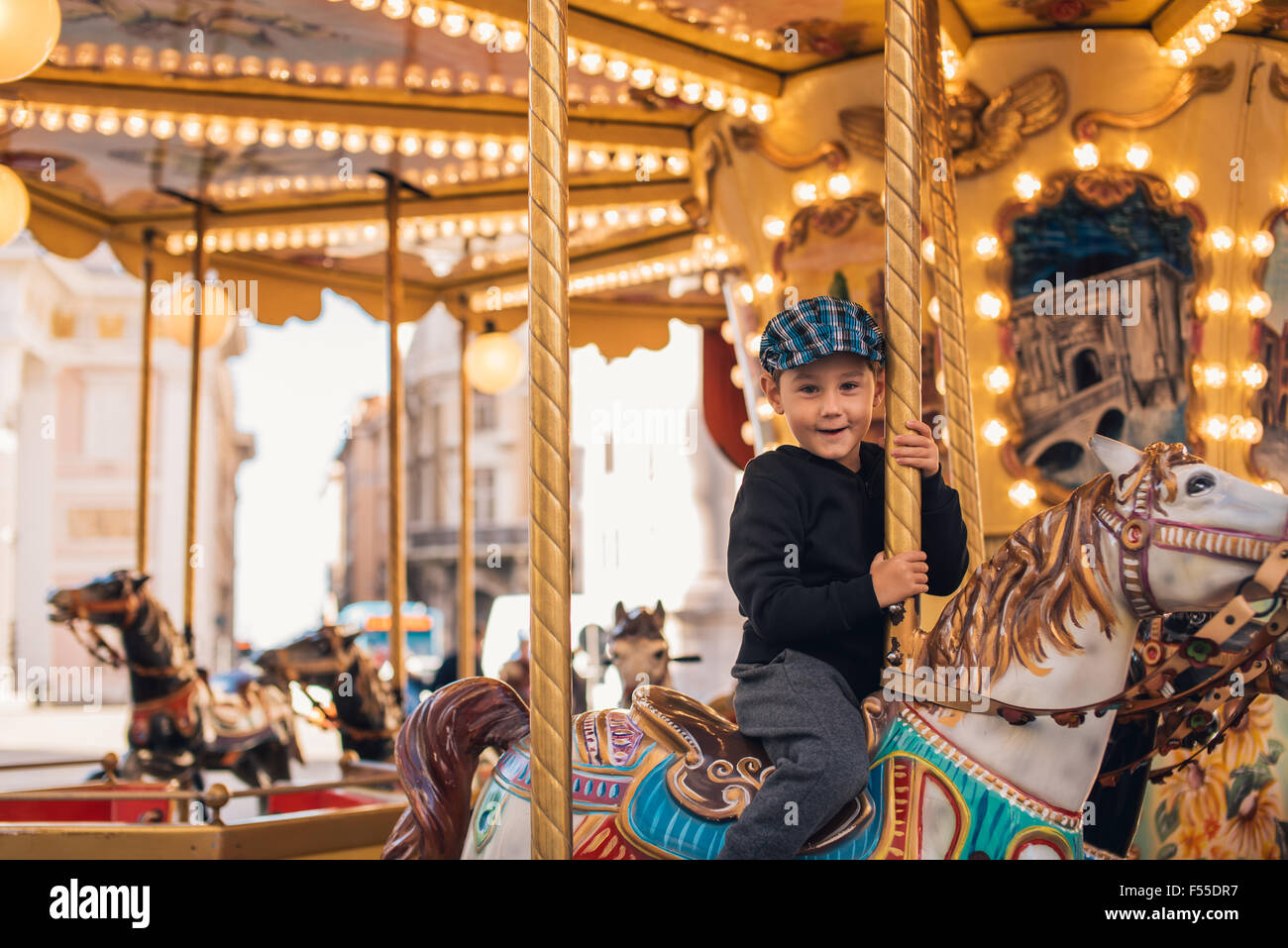 Little boy enjoying his ride at carousel in amusement park Stock Photo ...