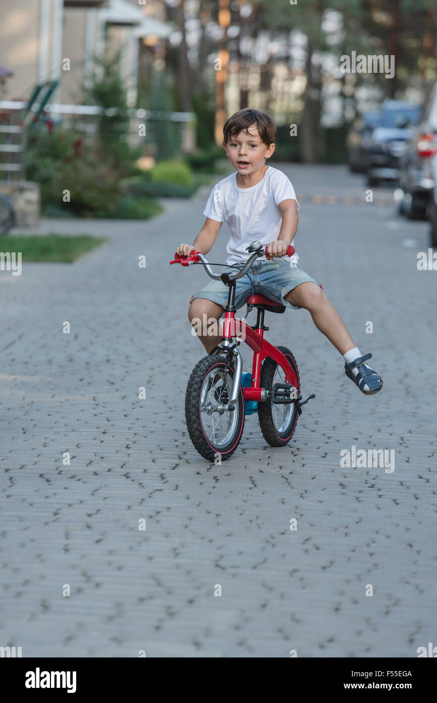 Boy riding bicycle on street Stock Photo - Alamy
