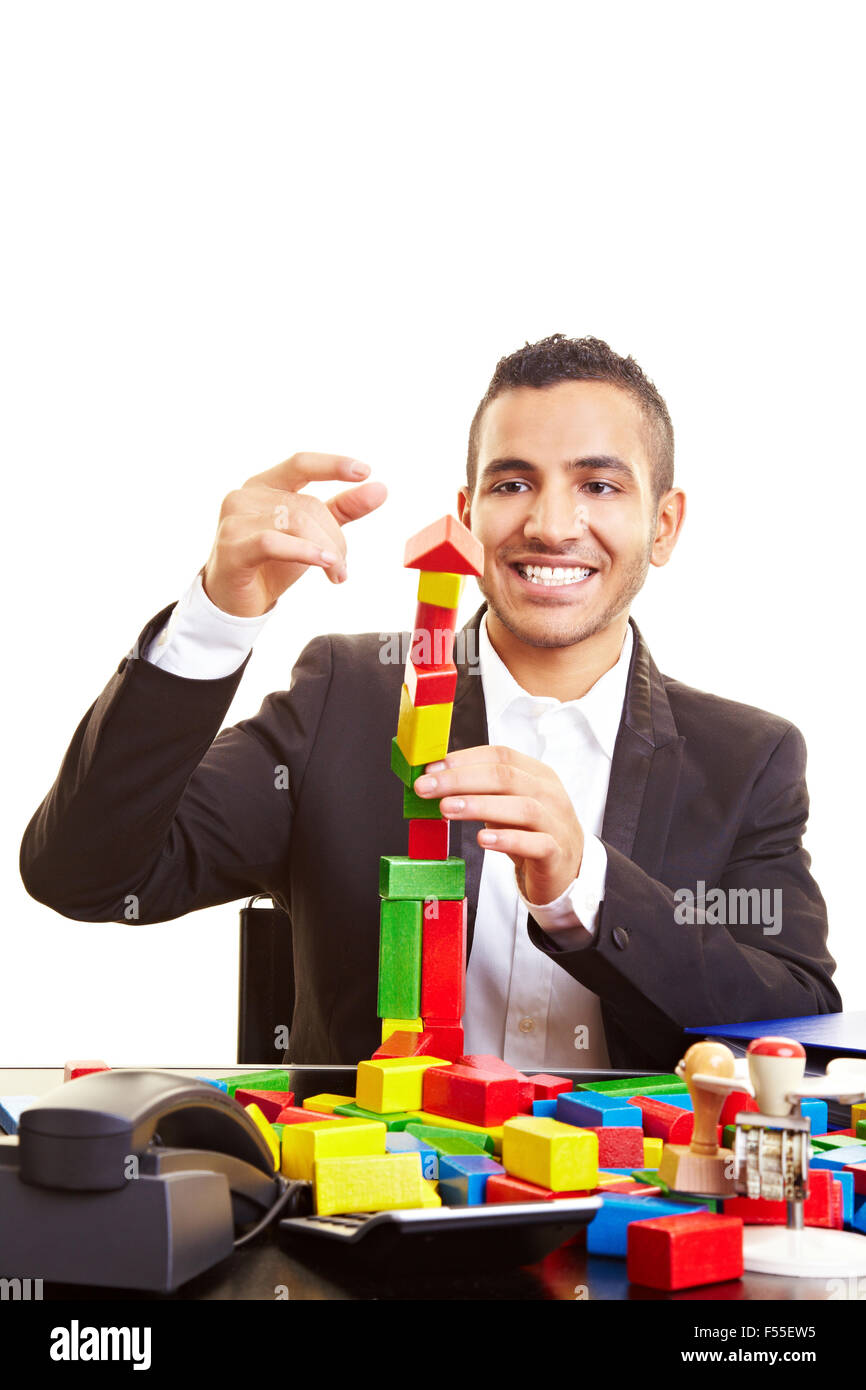 Young manager at his desk playing with colorful building bricks Stock ...