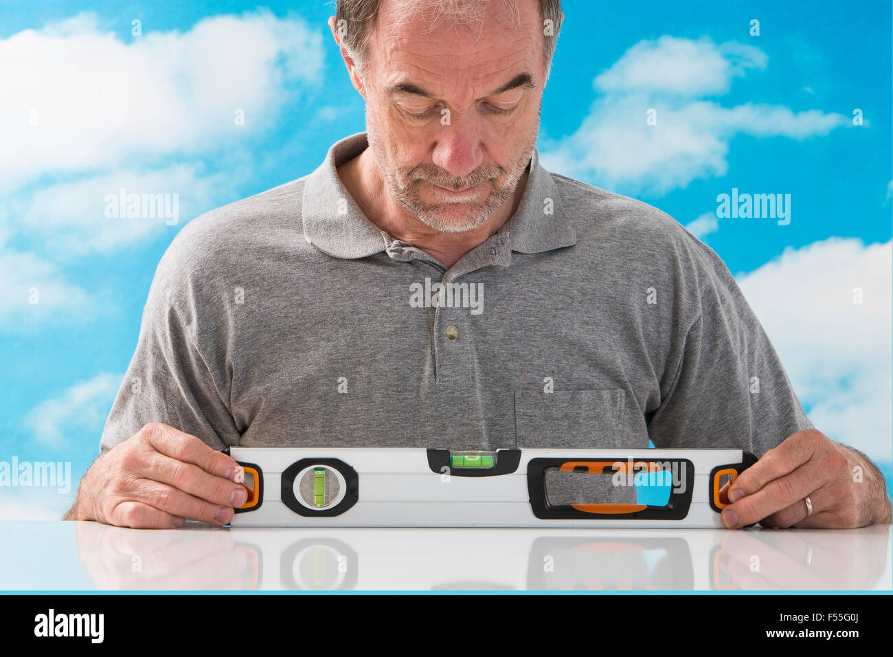 Senior man using measure level at home Stock Photo - Alamy
