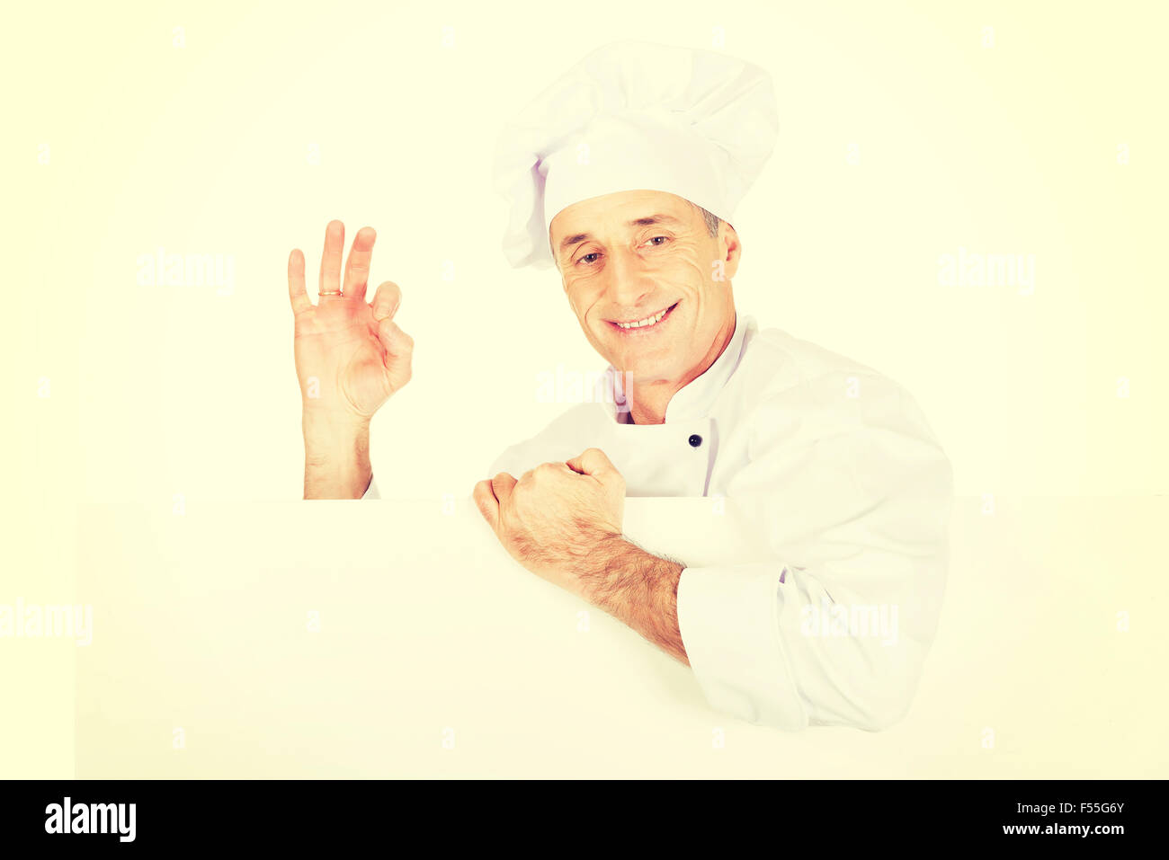 Chef in white uniform holding empty banner Stock Photo - Alamy