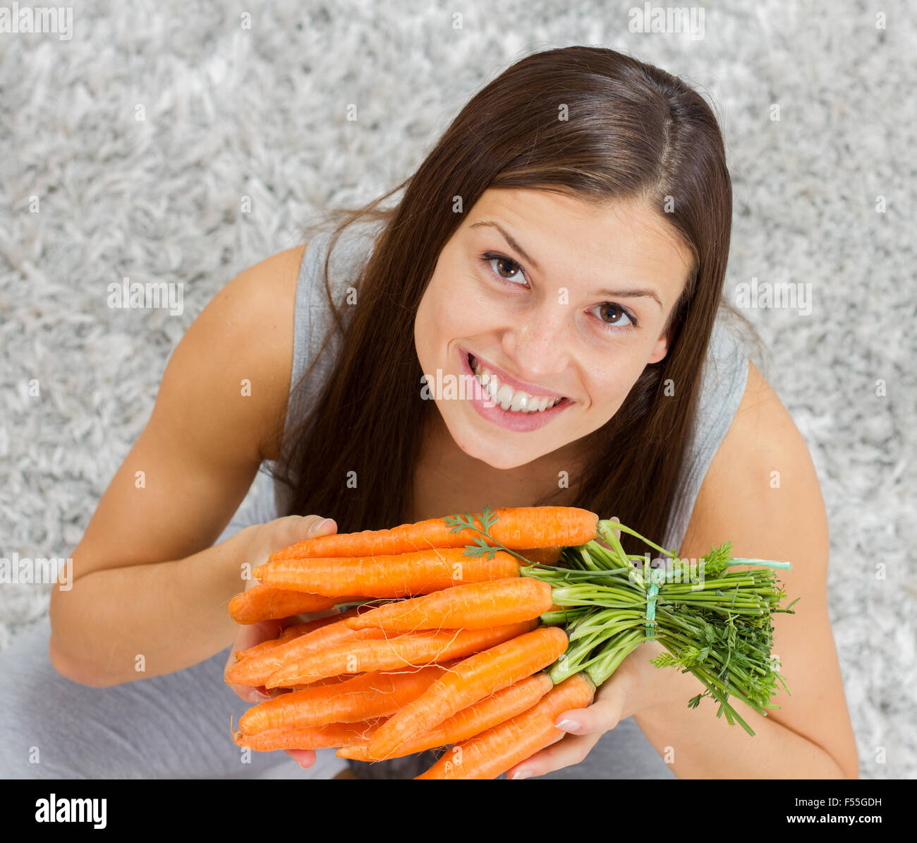 Fresh Carrots Bunch, holding smile young woman, in hand Stock Photo - Alamy