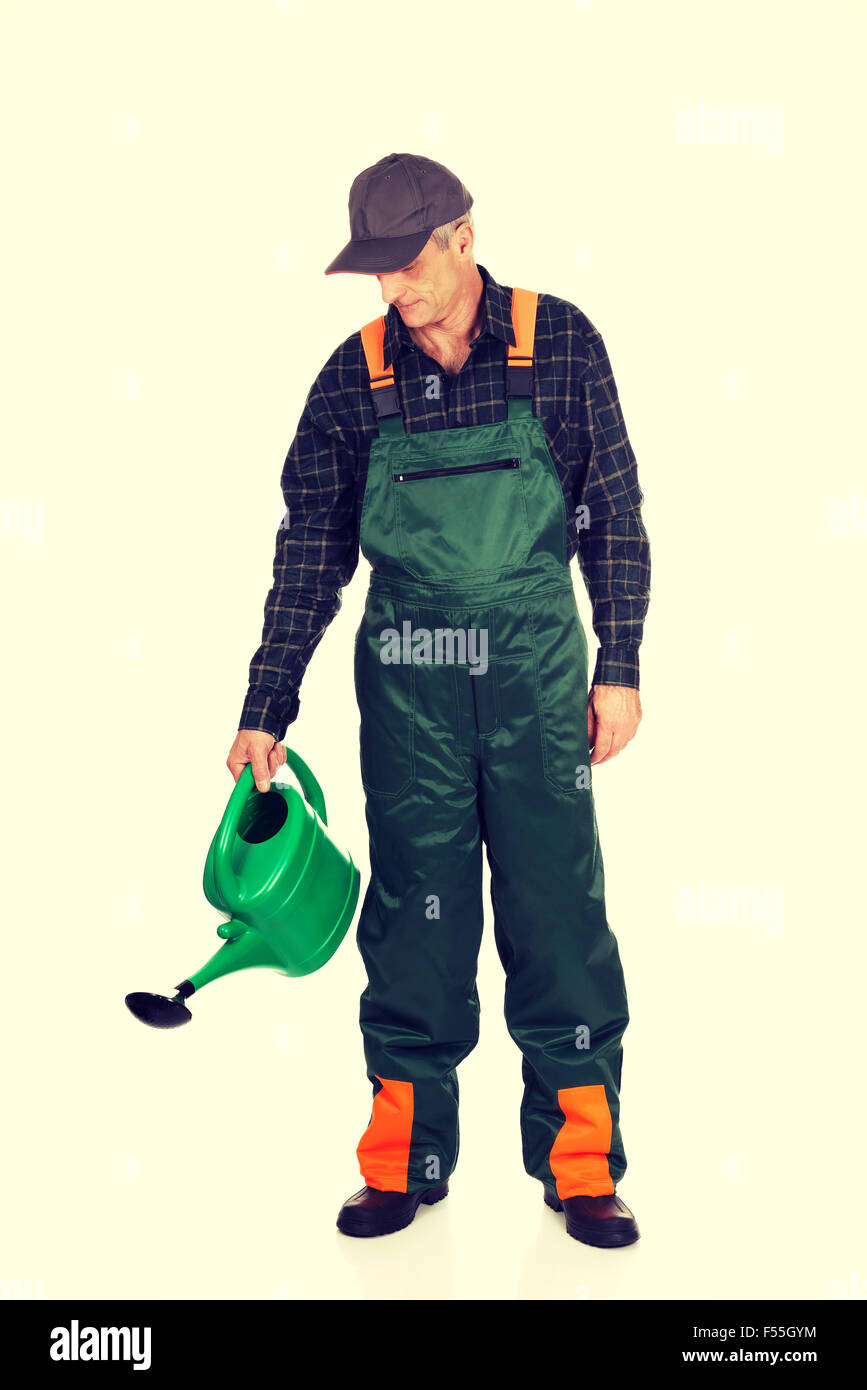 Workman pouring water from watering can Stock Photo - Alamy
