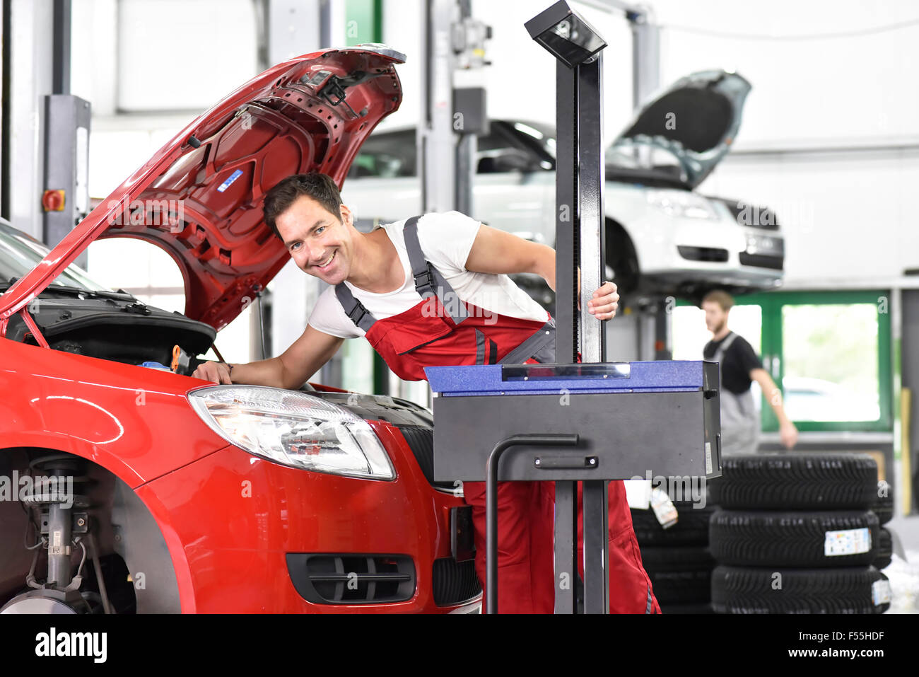 Car mechanic working in repair garage, setting car headlights Stock ...