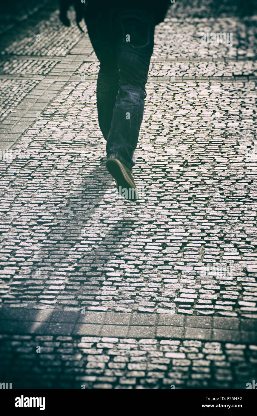 Mysterious man running on a cobbled street Stock Photo - Alamy
