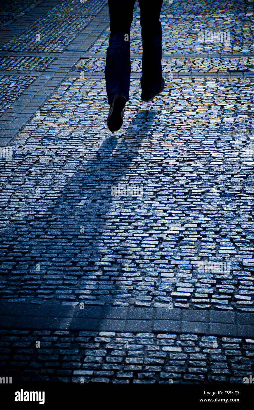 Mysterious man running on a cobbled street Stock Photo - Alamy