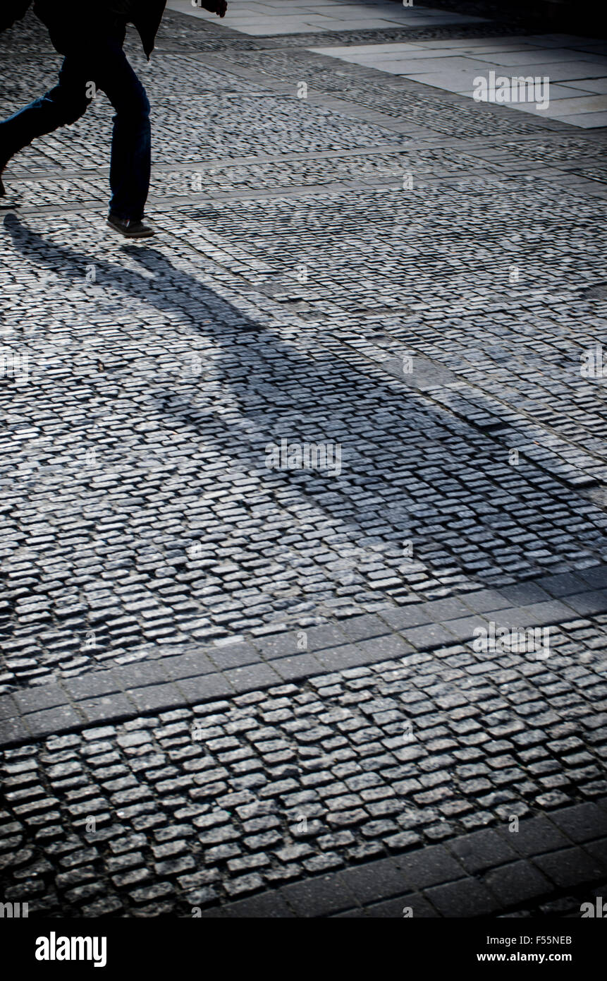 Mysterious man running on a cobbled street Stock Photo - Alamy