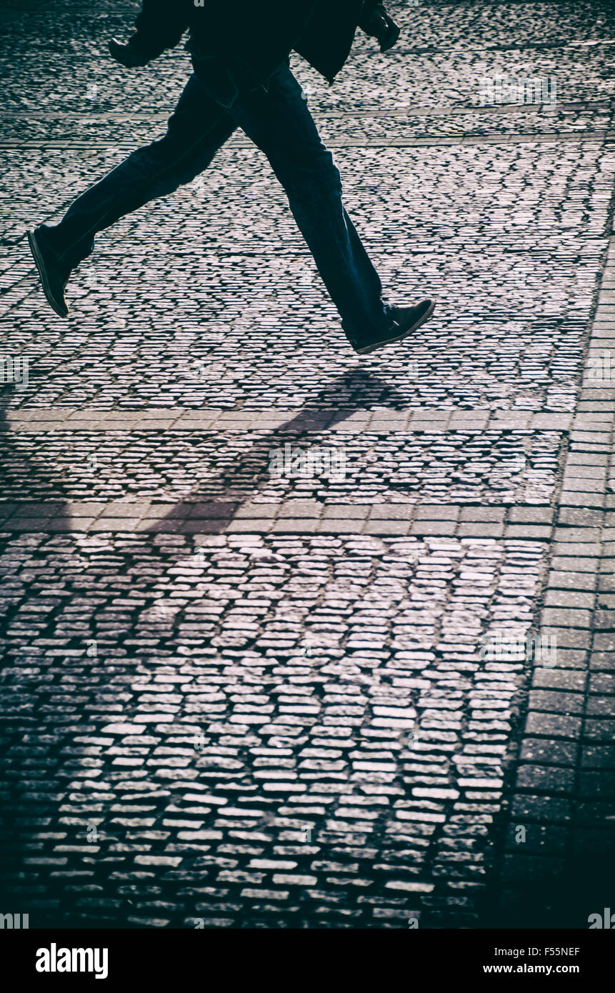 Mysterious man running on a cobbled street Stock Photo - Alamy