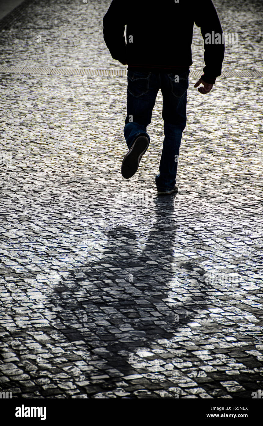 Mysterious man running on a cobbled street Stock Photo - Alamy